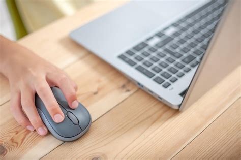 Premium Photo Closeup Of Hands Using A Mouse Next To A Laptop