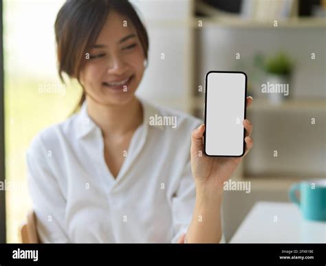 Portrait Of Smiling Female Showing Mock Up Smartphone Screen To Camera Clipping Path Stock
