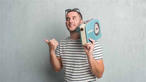 회색 그런 지 벽 고 행복 얼굴 웃 고 옆까지 엄지를 보여주는 빈티지 라디오에서 듣는 음악을 통해 젊은 백인 남자 가리키기에 대한 스톡 사진 및 기타 이미지 Istock