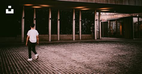 흰색 긴팔 셔츠와 검은 바지를 입은 남자가 낮 동안 보도를 걷고 있다 사진 Unsplash의 무료 사람 이미지