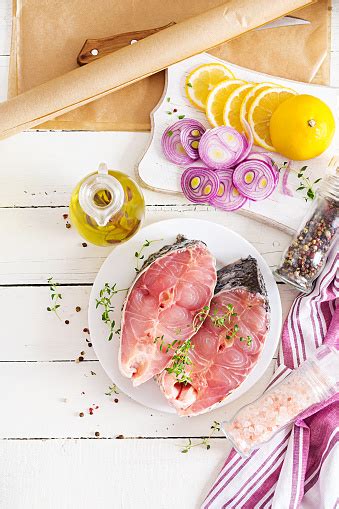 잉어 물고기 레몬 및 백색 나무 바탕에 백 리 향의의 원시 스테이크 물고기를 준비 하 고 양피지에 구이 다이어트 메뉴입니다 최고의 볼 수 있습니다 평면 배치 건강한 식생활에