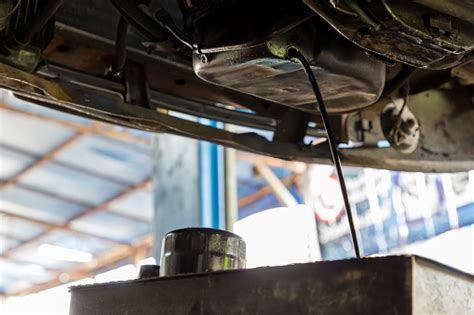 드레인 플러그를 통해 엔진에서 오래된 오일을 배출합니다 자동차 엔진의 오일 변경 자동차에서 폐유의 배출 사용 된 디젤 엔진 전원을 오일 팬에서 용기로 배출 석유에 대한 스톡