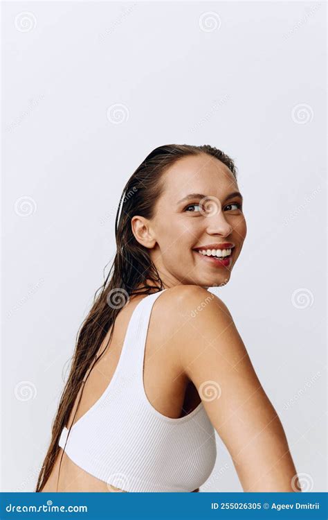 Woman Poses Sitting On Her Knees On The Floor With Beautiful Tanned Skin And Long Brown Hair
