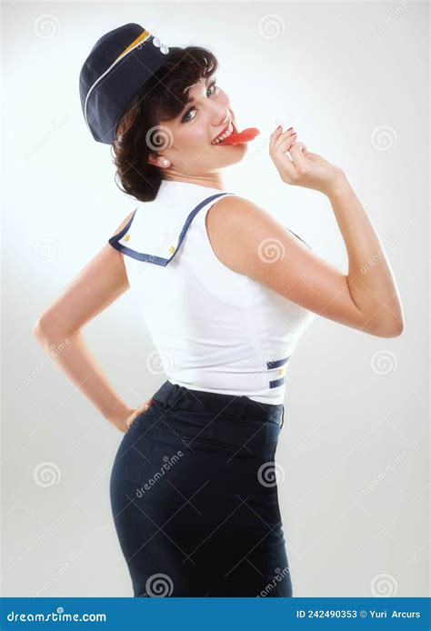 Naughty In Naughtical A Sailor Pinup Girl Posing Against White With A Lollipop Stock Image
