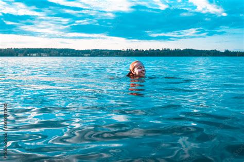 Finnish Girl Swimming In The Lake During Warm Scandinavian Midsummer
