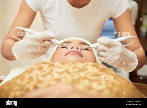 Highly Professional Beautician Using Microcurrent Machine While