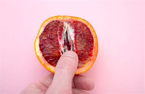 Premium Photo Person Touching Slice Of The Juicy Red Orange With Form As Female Vagina Creativity