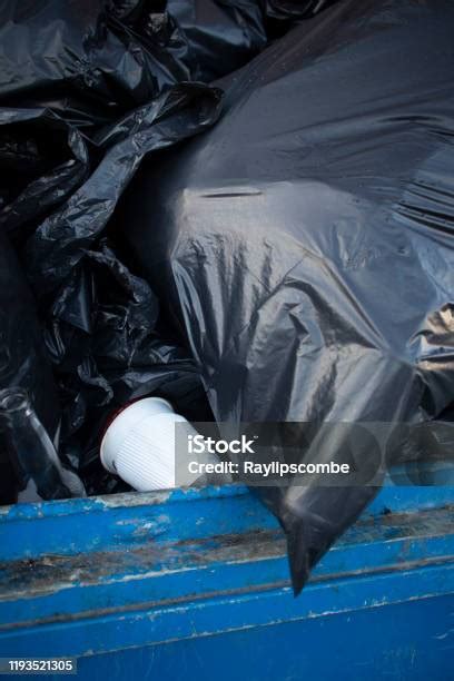 영국 글로스터셔 주 첼튼햄에 있는 상점 뒤쪽에서 버려진 골판지 검은 색 쓰레기통 라이너 및 종이로 가득 찬 쓰레기 쓰레기 쓰레기