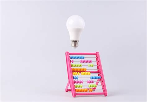 Premium Photo Colored Abacus And A Floating Light Bulb On A White
