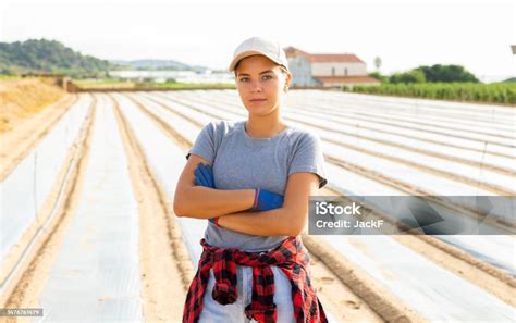 폴리에틸렌 뿌리 덮개로 덮인 농장에 서 있는 웃는 소녀 농장 노동자 20 24세에 대한 스톡 사진 및 기타 이미지 20 24