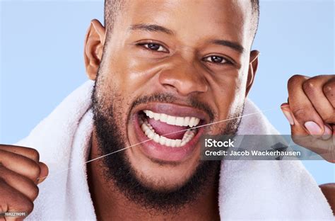 초상화 남자와 치실 이빨은 스튜디오에서 건강 치과 및 잇몸 치은염의 자기 관리 흑인 남성 모델의 얼굴 신선한 숨결 치아 위생 또는 파란색 배경에 플라크를 위한 실 또는 청소