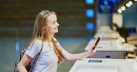 배낭을 메고 체크인 카운터에서 국제 공항에 수하물을 들고 경찰관에게 여권을 주고 탑승권을 기다리는 아름다운 젊은 관광 소녀 사진