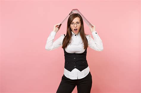 젊은은 비즈니스 우먼 핑크 배경에 고립 된 집의 지붕 처럼 머리에 종이 문서에 대 한 폴더를 들고 안경에 자극 여자 보스입니다