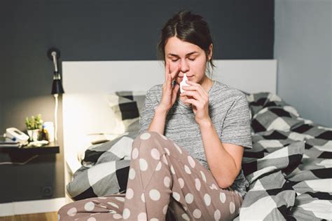 주제는 계절 감기 콧 물 코 독감 바이러스 감염 홈 침실 침대에 젊은 백인 여자 코 딱지에 대 한 그녀의 코에 의학의 스프레이 방울을 사용합니다 축 농 증 및 알레르기