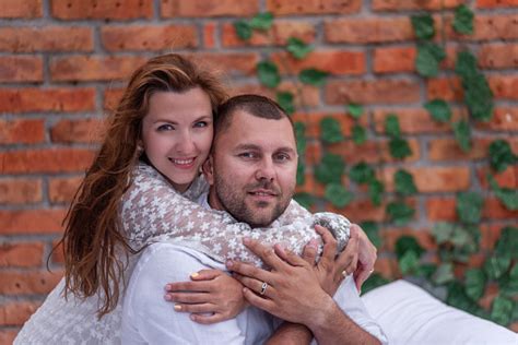 사랑스러운 부부 밀레니엄 세대는 녹색 아이비와 벽돌 벽의 배경에 흰색 침대에 껴안고있다 사랑에 대한 스톡 사진 및 기타 이미지 사랑 2명 30 34세 Istock