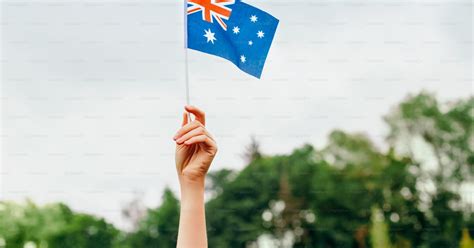 푸른 하늘을 배경으로 호주 국기를 흔드는 여성 인간의 손 팔의 클로즈업 1월 야외에서 호주 국가의 날을 축하하는 자랑스러운 시민 남성 국경일 휴일 사진