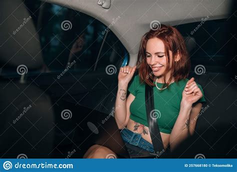 Beautiful Woman Is Using Laptop While Sitting On Back Seat Stock Photo