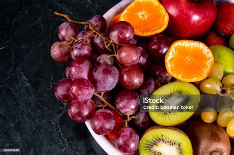 검은색 대리석에 그릇에 신선한 열 대 과일 파인애플 파파야 망고 키 위 포도 석류 석 귤 바나나 사과 수 박 조각 Pitaya 또는 드래곤 과일 0명에 대한 스톡 사진 및