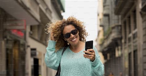 초상화 F 쾌활한 성인 아름다운 여자는 도시의 거리에서 현대 기술 셀룰러 산책으로 전화를 걸고 있습니다 야외 도시 장소 레저 활동과 트렌디한 사람들이 웃고 즐기는 개념