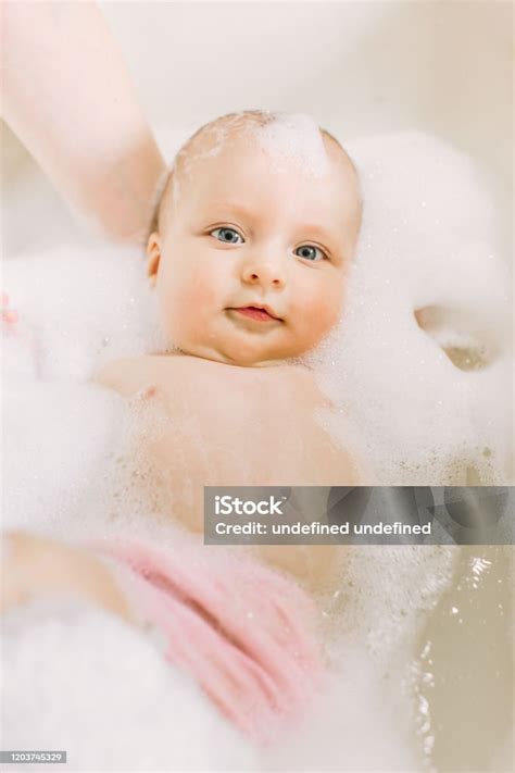 거품 거품으로 노는 목욕을하는 행복한 웃음 아기 욕조에 어린 아이 유아 세탁 및 입욕 어린 아이들을 위한 위생 및 배려 화장실에서 작은 아기의 얼굴 신생아에 대한 스톡 사진