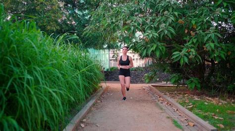 A Woman Running On A Path Through A Park Stock Video At Vecteezy