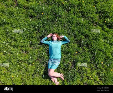 Beautiful Girl Lying Down Of Grass The Girl Lies In A Turquoise Dress
