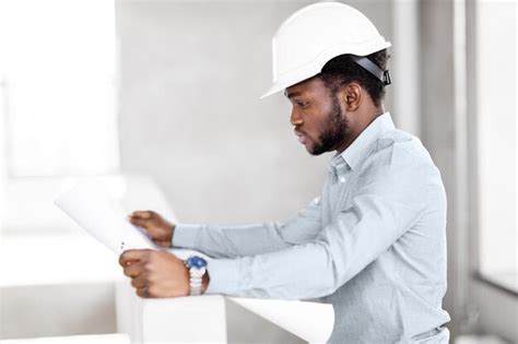 Premium Photo African Architect In Helmet With Blueprint