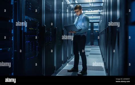 In Data Center It Engineer Stands Before Working Server Rack Doing Routine Maintenance Check And