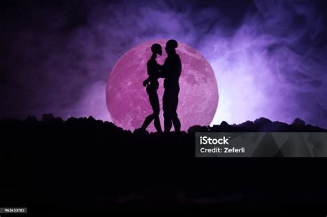 보름달 아래 키스 하는 커플의 실루엣입니다 보름달 실루엣 배경에 남자 키스 여자 핸드 발렌타인의 날 장식 개념입니다 사랑 하는