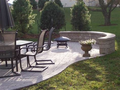 An Outdoor Patio With Chairs Table And Fire Pit In The Middle Of Grass Area
