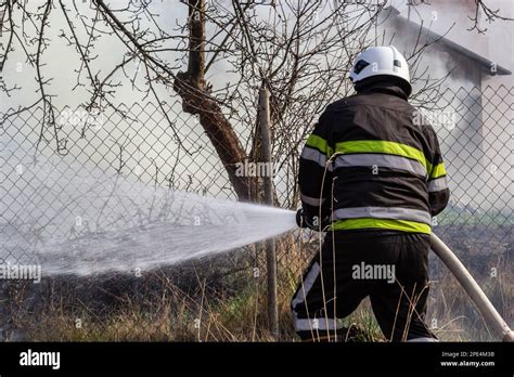 Spring Fire Burning Dry Grass Near Buildings In The Countryside