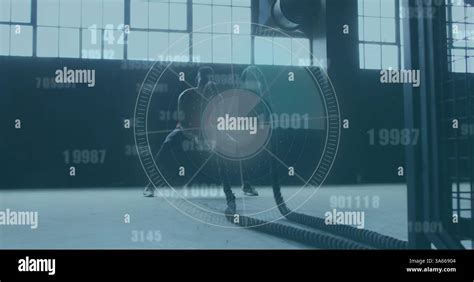 Image Of Floating Numbers Over Man Exercising With Ropes In An Abandoned Building Stock Photo