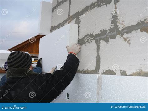 Contractors Installing Rigid Styrofoam Insulation Board On House