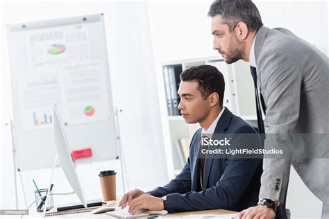 데스크톱 컴퓨터와 사무실에서 함께 일 하는 심각한 실업가의 모습 경영자에 대한 스톡 사진 및 기타 이미지 경영자 기업