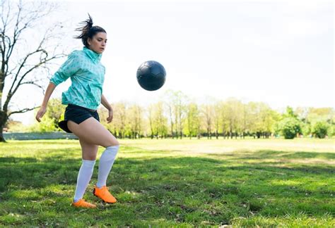 Free Photo Portrait Of Young Woman Practicing Soccer Skills And Doing Tricks With The Football