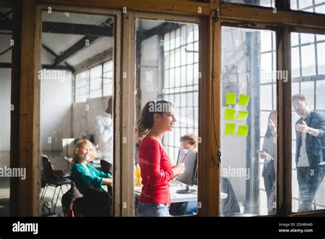Computer Professionals Brainstorming In Board Room While Discussing Over Adhesive Notes At
