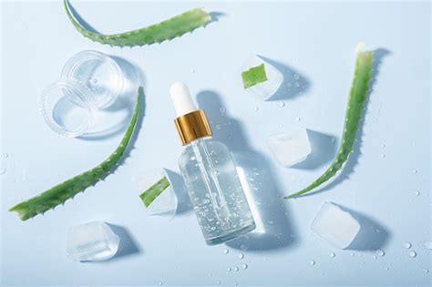 하늘색 배경에 스포이드 얼음 조각 알로에 잎이 있는 투명한 화장품 병 알로에 베라 추출물 노화 방지 피부 관리 보습 및 클렌징의 개념 공간을 복사합니다 생활필수품에 대한