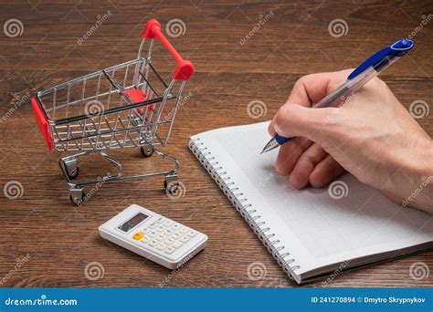 Budget Calculation Man Calculates The Budget Shopping Cart A On Table With Calculator And