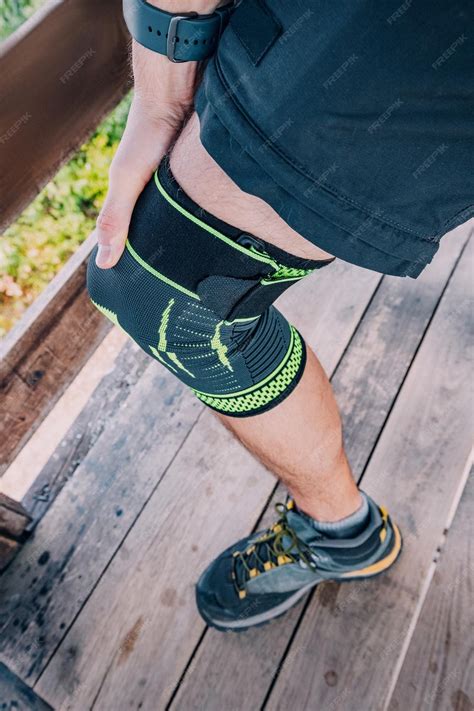 Premium Photo Adult Runner In A Park Wearing An Elastic Brace For A Knee Sprain While Staying