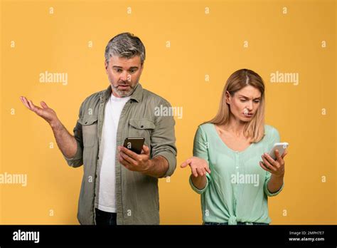 Internet Connection Problem Confused Middle Aged Caucasian Couple Looking At Their Phones And