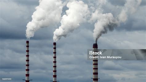 극적인 하늘 배경에 굴뚝에서 산업 연기 석탄 발전소에서 회색 연기가 나는 높은 굴뚝 파이프의 전망 화석 연료로 전기 생산 바람이