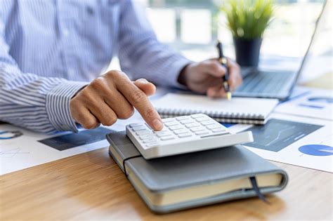 계산기를 사용하여 회사의 재무 문서에 숫자를 계산하는 사업가인 그는 회사의 재무 문서에서 숫자를 계산하여 회사 성장 방법을 계획하기 위해 역사적인 재무 데이터를 분석하고