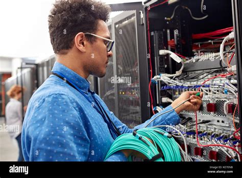 Male IT Technician Plugging Cable Into Panel In Server Room Stock Photo Alamy