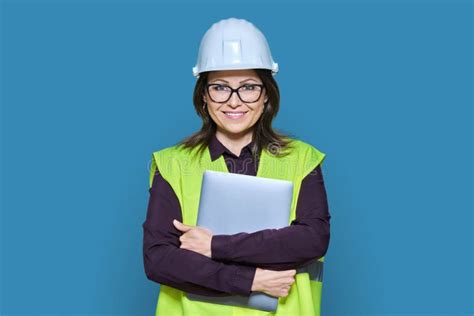 Portrait Of Engineer Manager Woman In Helmet Vest Holding Laptop Stock