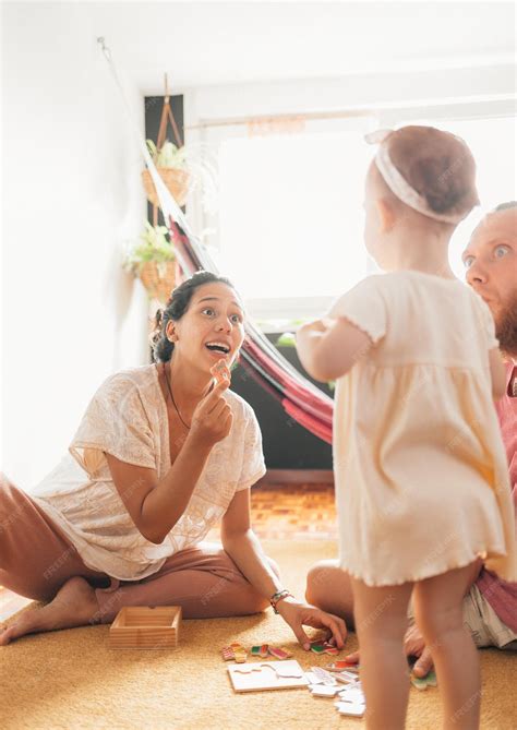 Premium Photo Mother And Father Caught Playing With Their Young Daughter