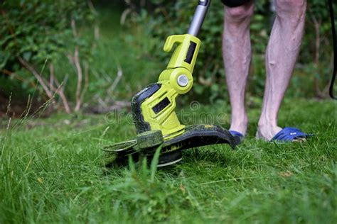 Process Of Cutting Grass With A Professional Grass Trimmer Stock Image