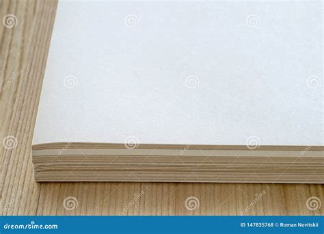 A Stack Of Sheets Of Clean Paper Lies On The Surface Of The Table With A Natural Texture Of Wood
