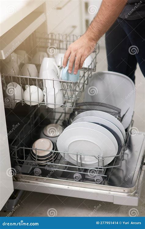 Cleaning Loading Dishwasher And Hands With Dishes In The Kitchen For