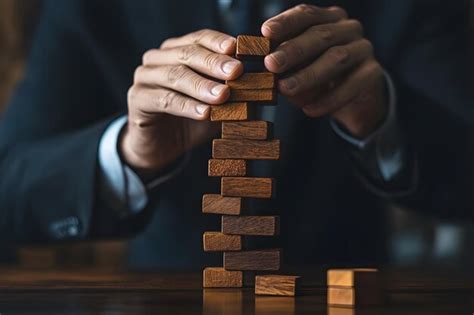 Businessman Stacking Wooden Blocks In A Tower Concept Of Strategy Risk Management And Decision