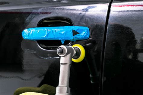 자동차 폴란드어 왁 스 작업자 연마 하기 전에 적용 보호 테이프를 손 버프 하 고 차를 연마입니다 자동차 적입니다 남자 손에서 폴 리 셔를 보유 하 고 차를 닦 Waxing